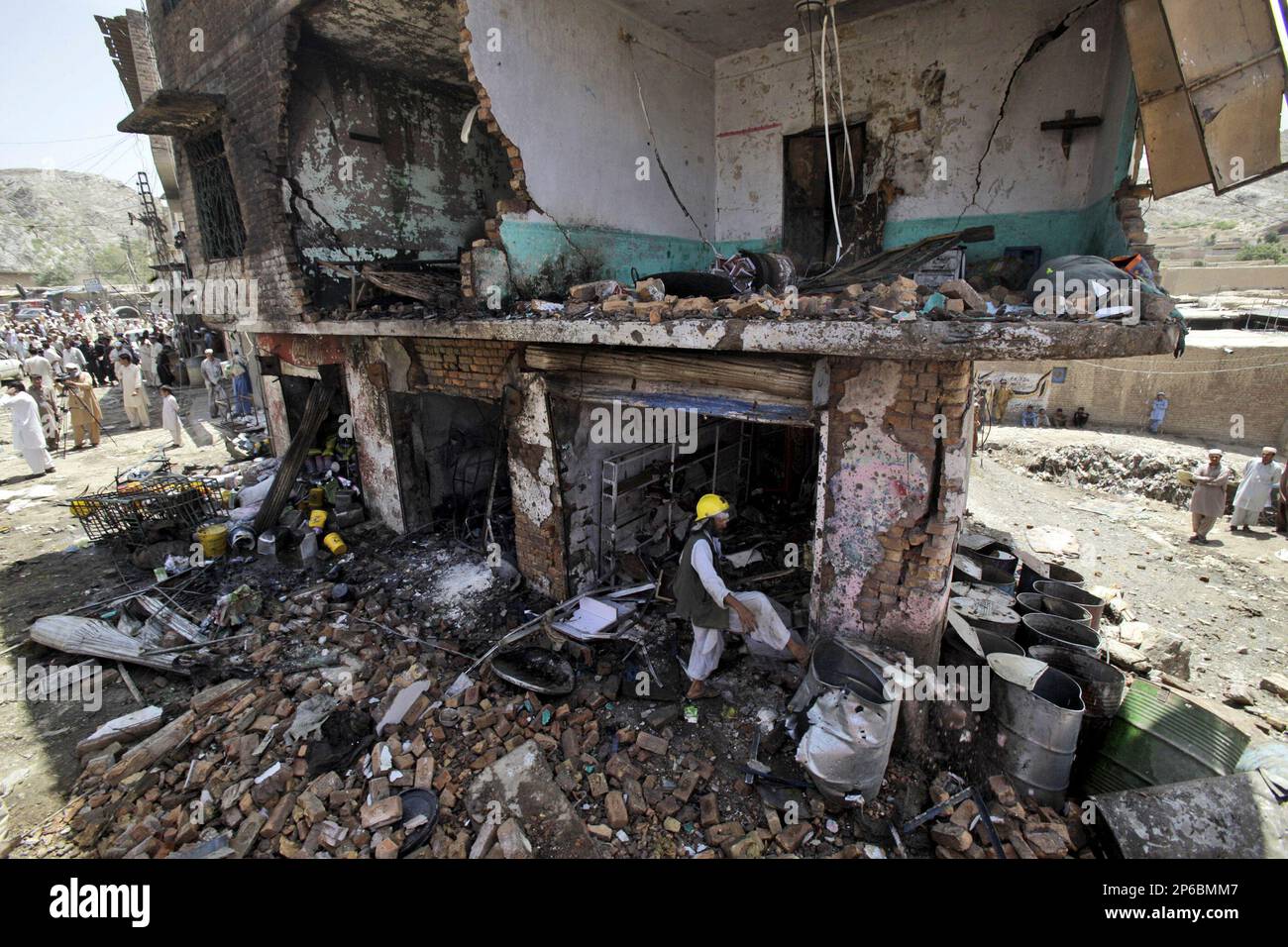 Pakistanis gather at the site of a car explosion in Landi Kotal ...