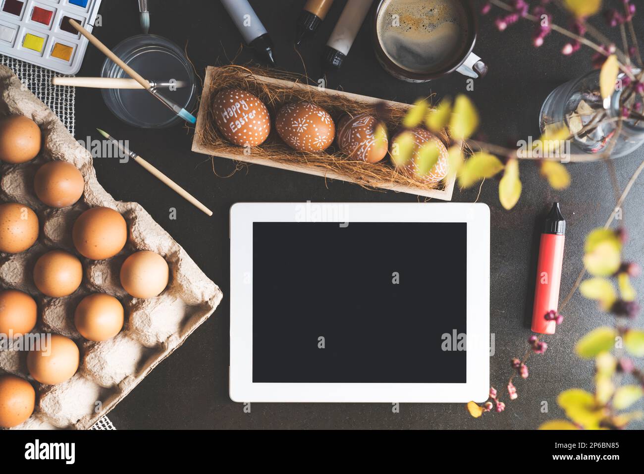 Making hand painted easter eggs with simple patterns. Top view table ...