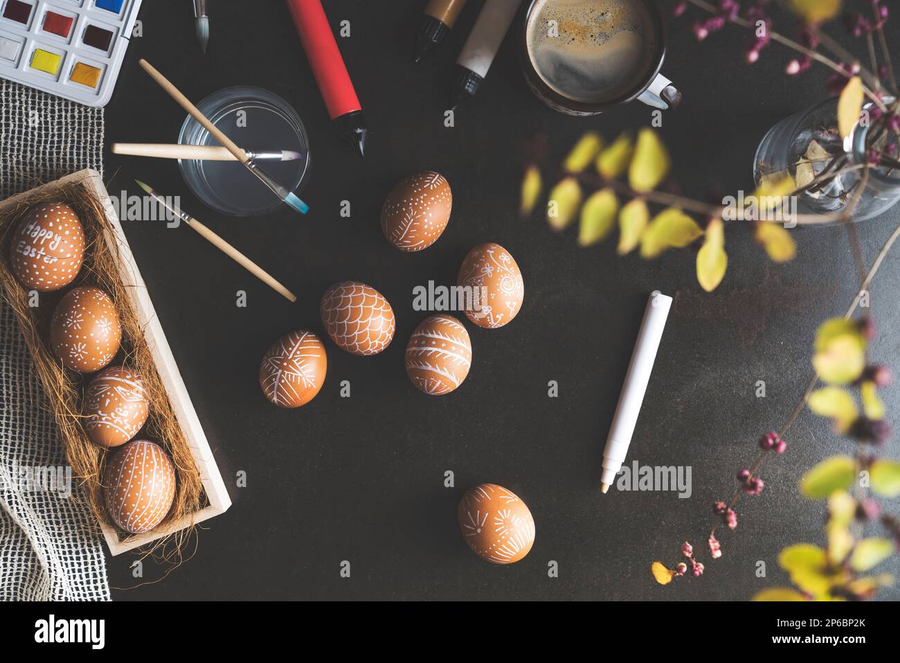 Making hand painted easter eggs with simple patterns. Top view table ...