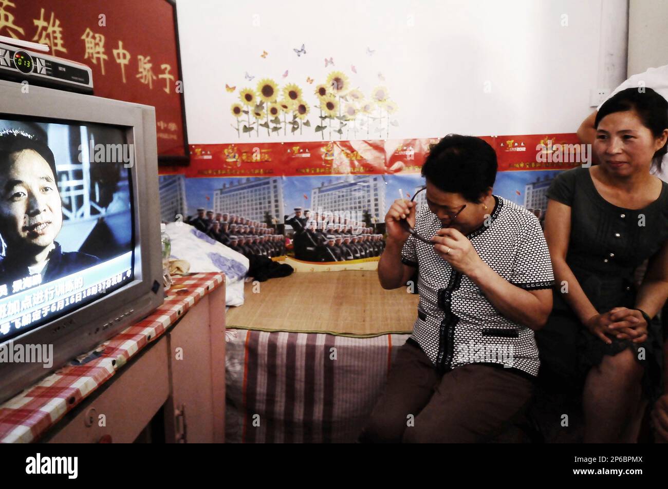 Chinese astronaut Jing Haipeng's mother Wang Zhenlin (L) watches the news conference of China's ...