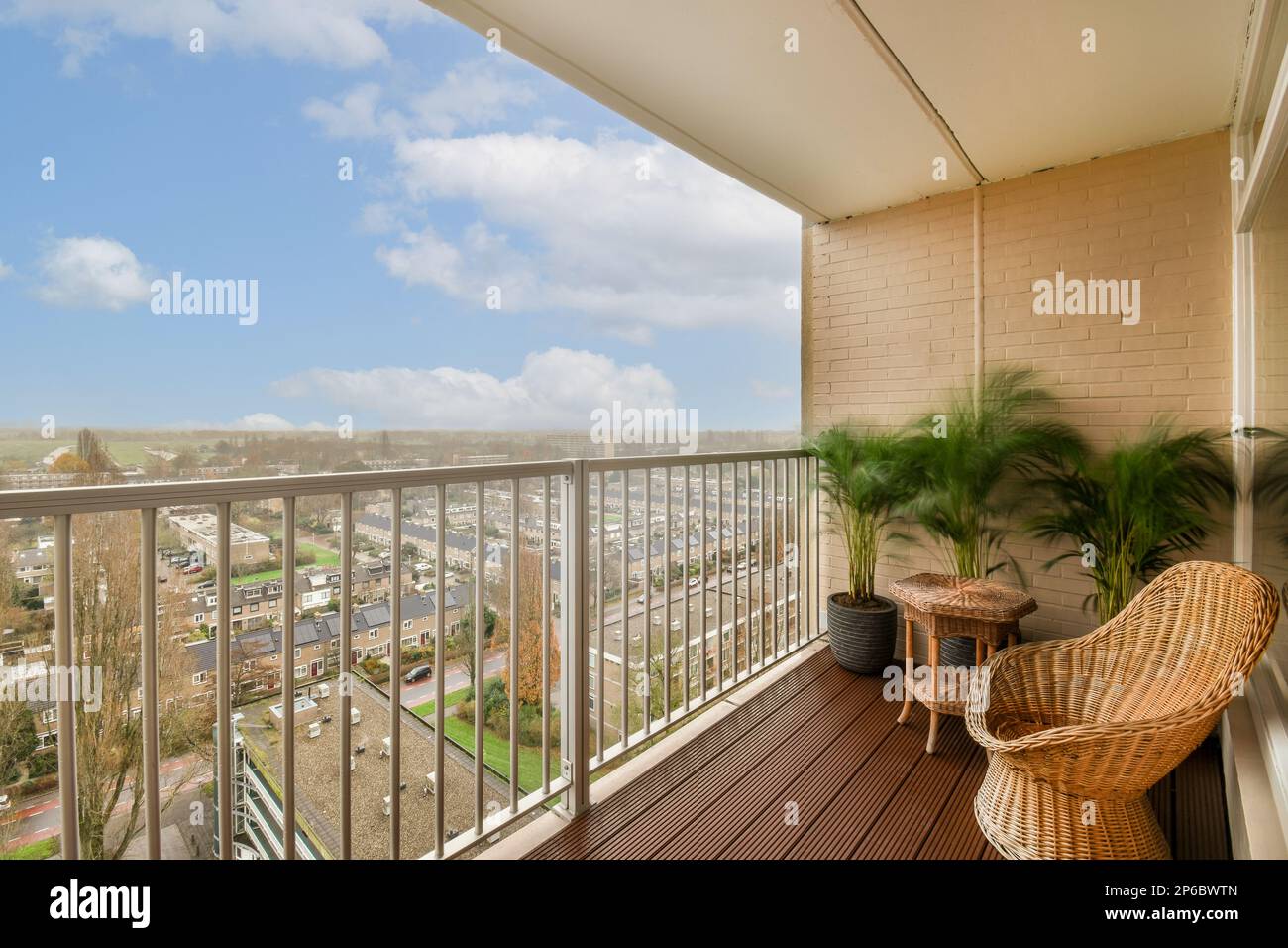 a balcony with a chair and potted plant on the outside deck looking out ...