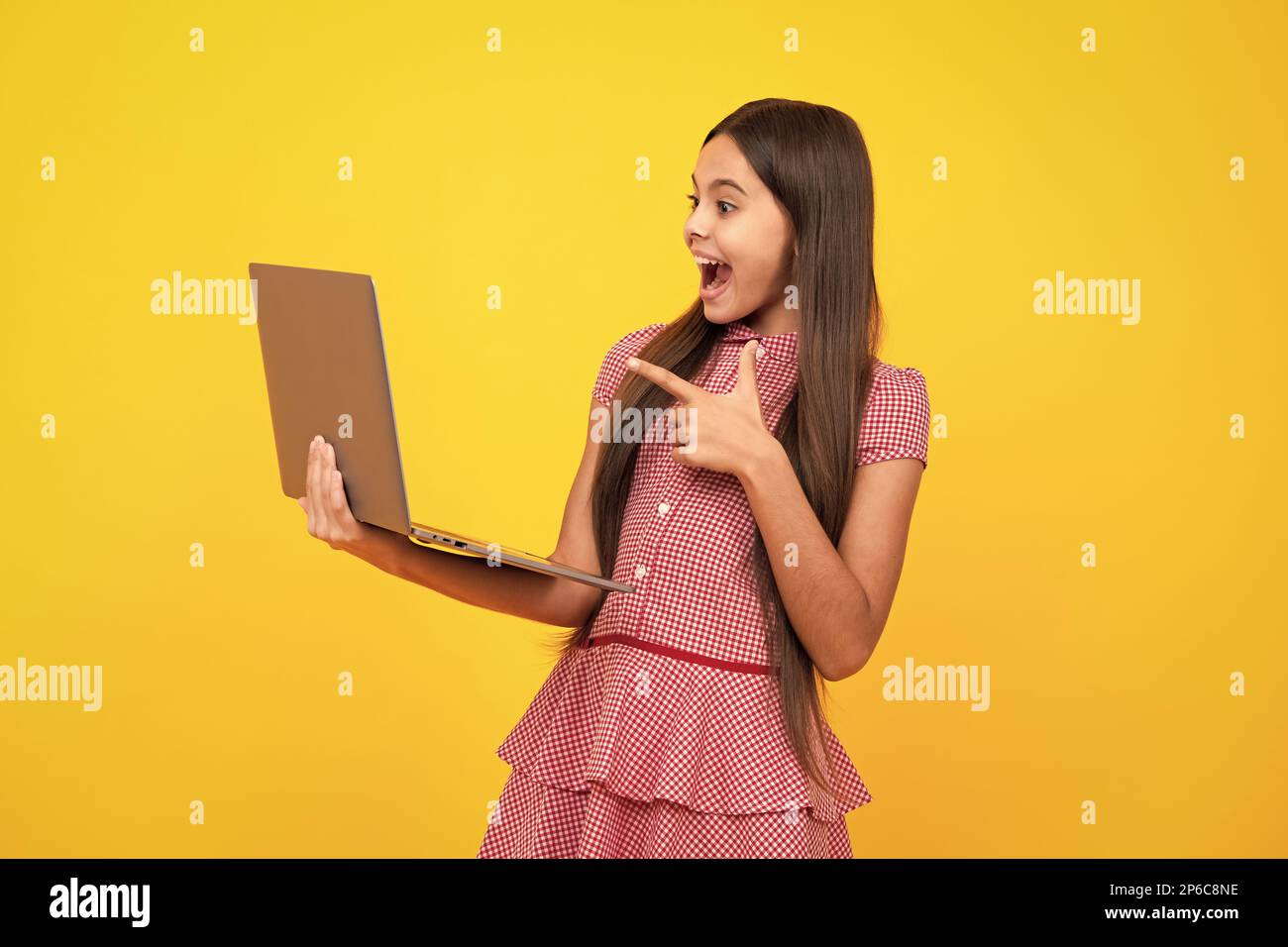 Amazed teen girl. Student school girl with laptop on isolated studio ...