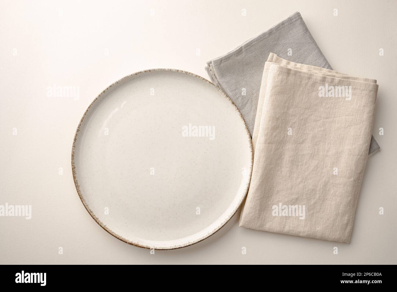 Cream-colored plate and linen napkins on a table Stock Photo - Alamy