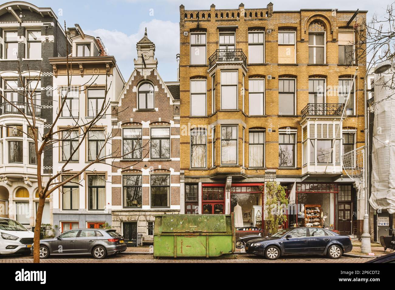 a street with cars parked on the side and buildings in the back ground ...