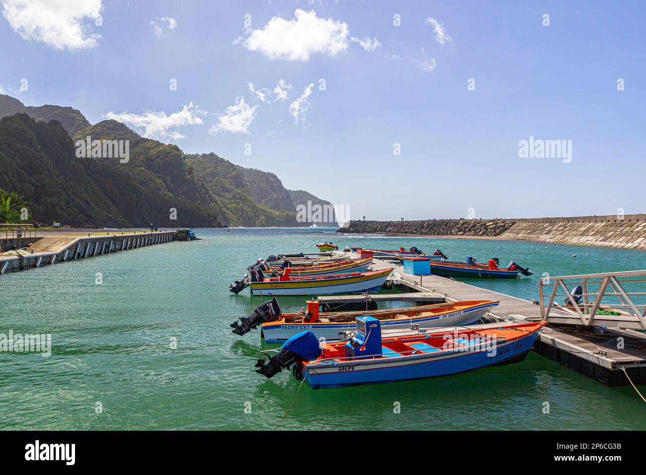 colored fishing boat on a pontoon Stock Photo - Alamy