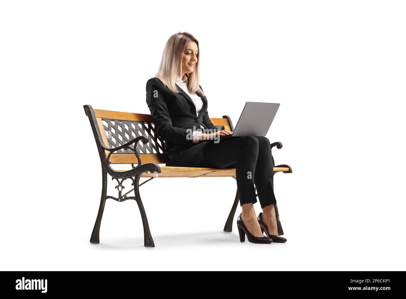 Businesswoman sitting on a bench and using a laptop computer isolated ...