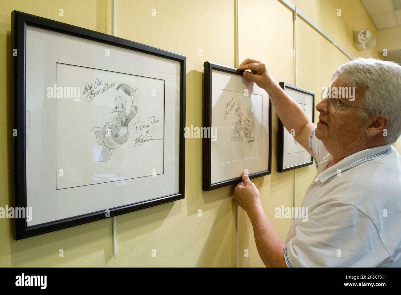 Jamie Lavin hangs up art work inside the Buttonwood Art Space for the ...