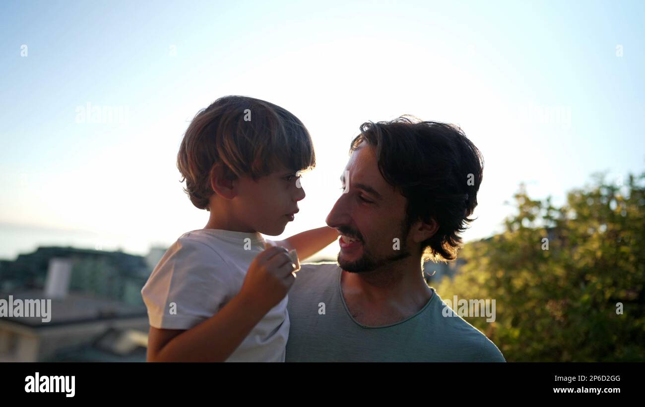 Child embracing father in sunset time. Father and son bonding moment ...
