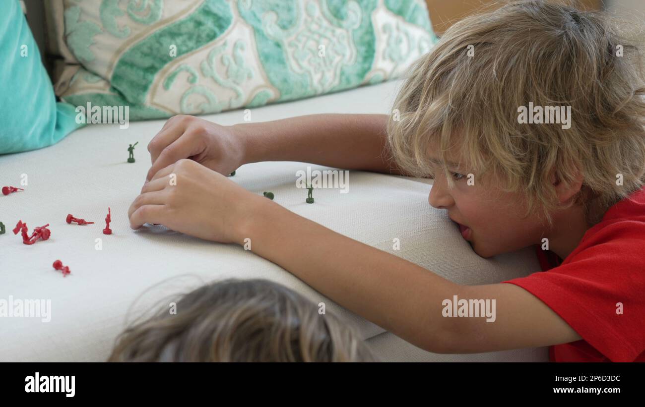 Child plays with toy soldiers. Candid young boy playing with figurines ...