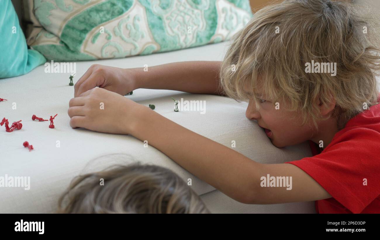 Child plays with toy soldiers. Candid young boy playing with figurines ...