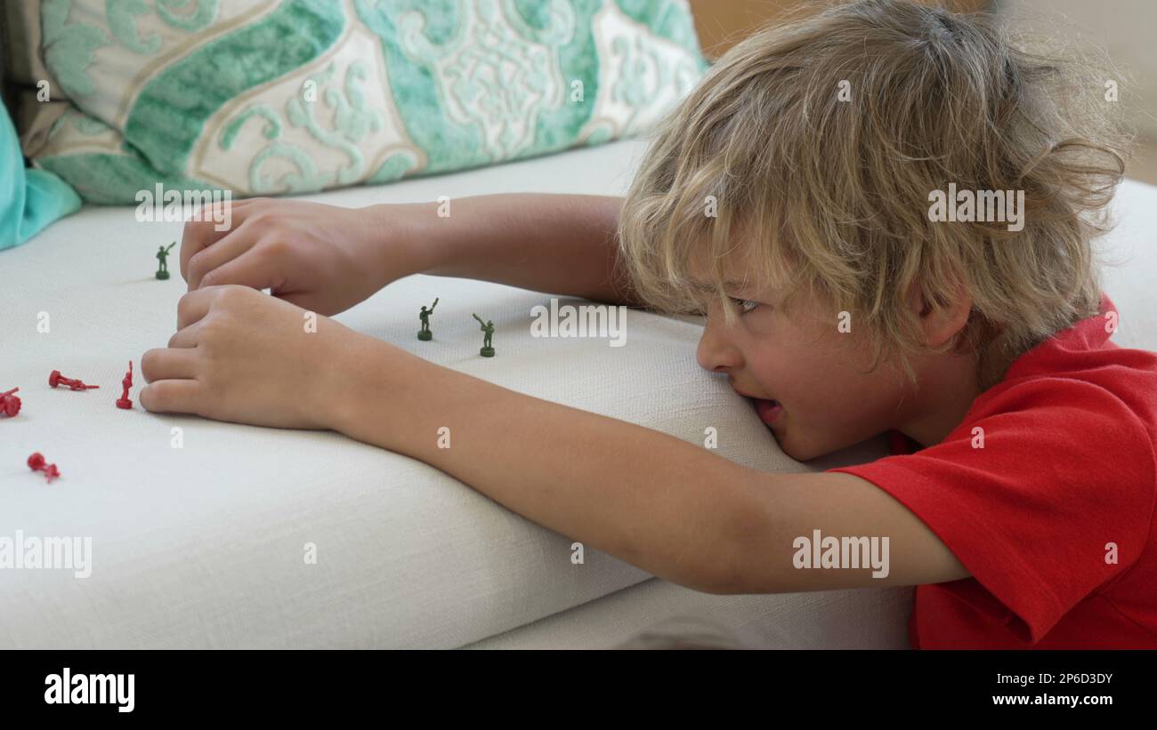 Child plays with toy soldiers. Candid young boy playing with figurines ...