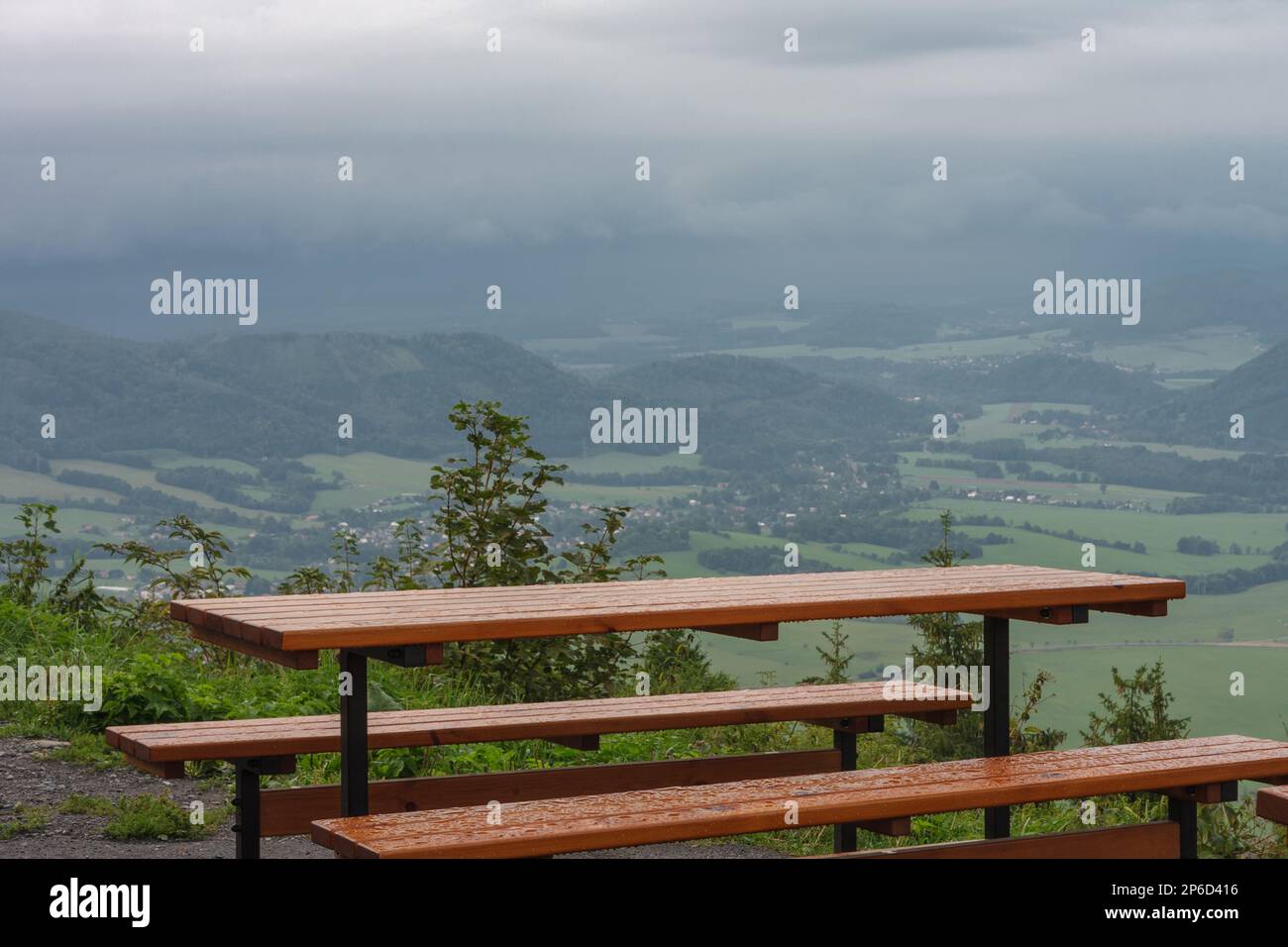 Wooden benches and table, view from Javornik to mountain village in ...