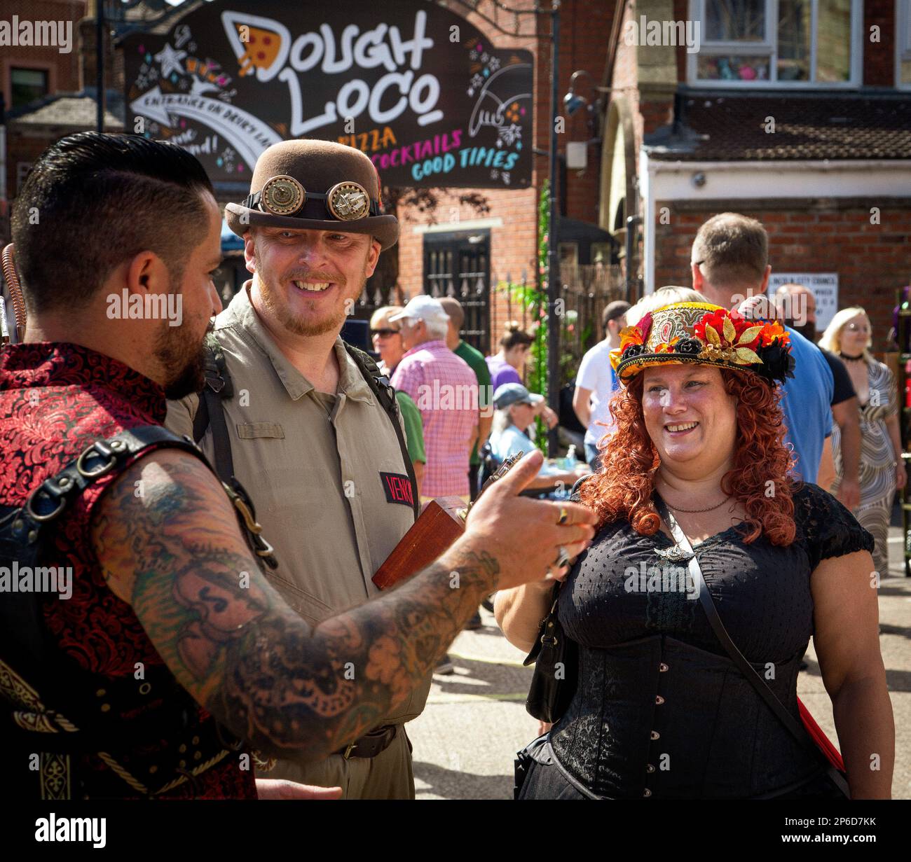 A group of friends enjoying a conversation at a steampunk event Stock ...