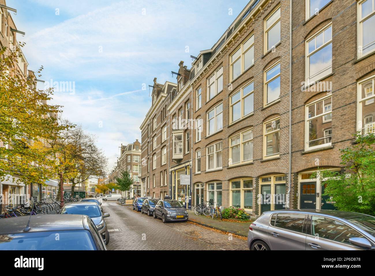 a city street with cars parked on the side and buildings in the ...
