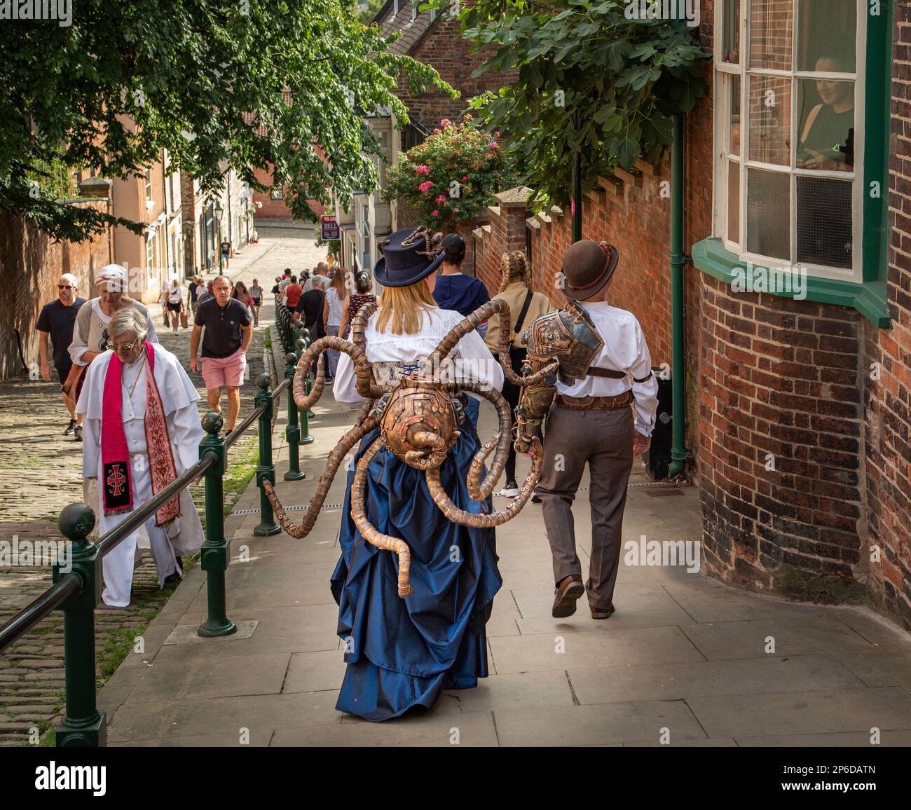 A female steampunk walks through the street with a large copper octopus ...