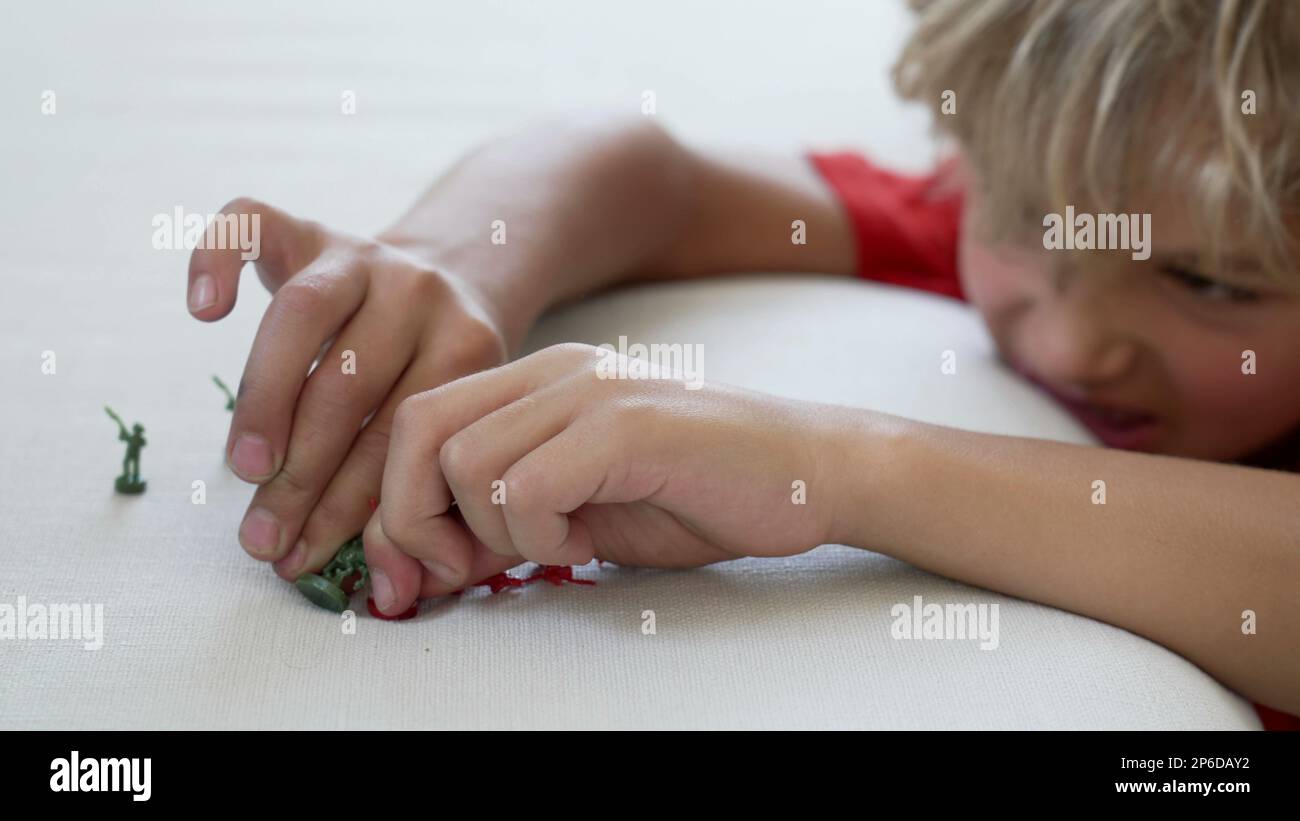 Close up of child hands playing with miniature figurines. One ...