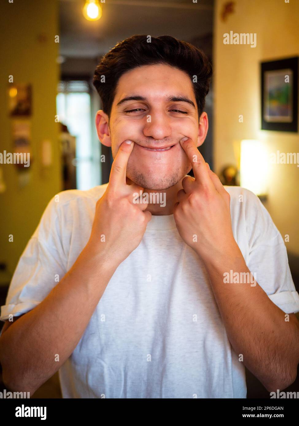 Young man forcing his mouth to smile by pushing with fingers Stock ...