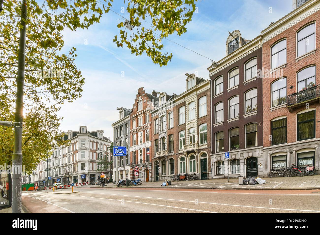 a city street with many buildings and people walking on the sidewalk in ...