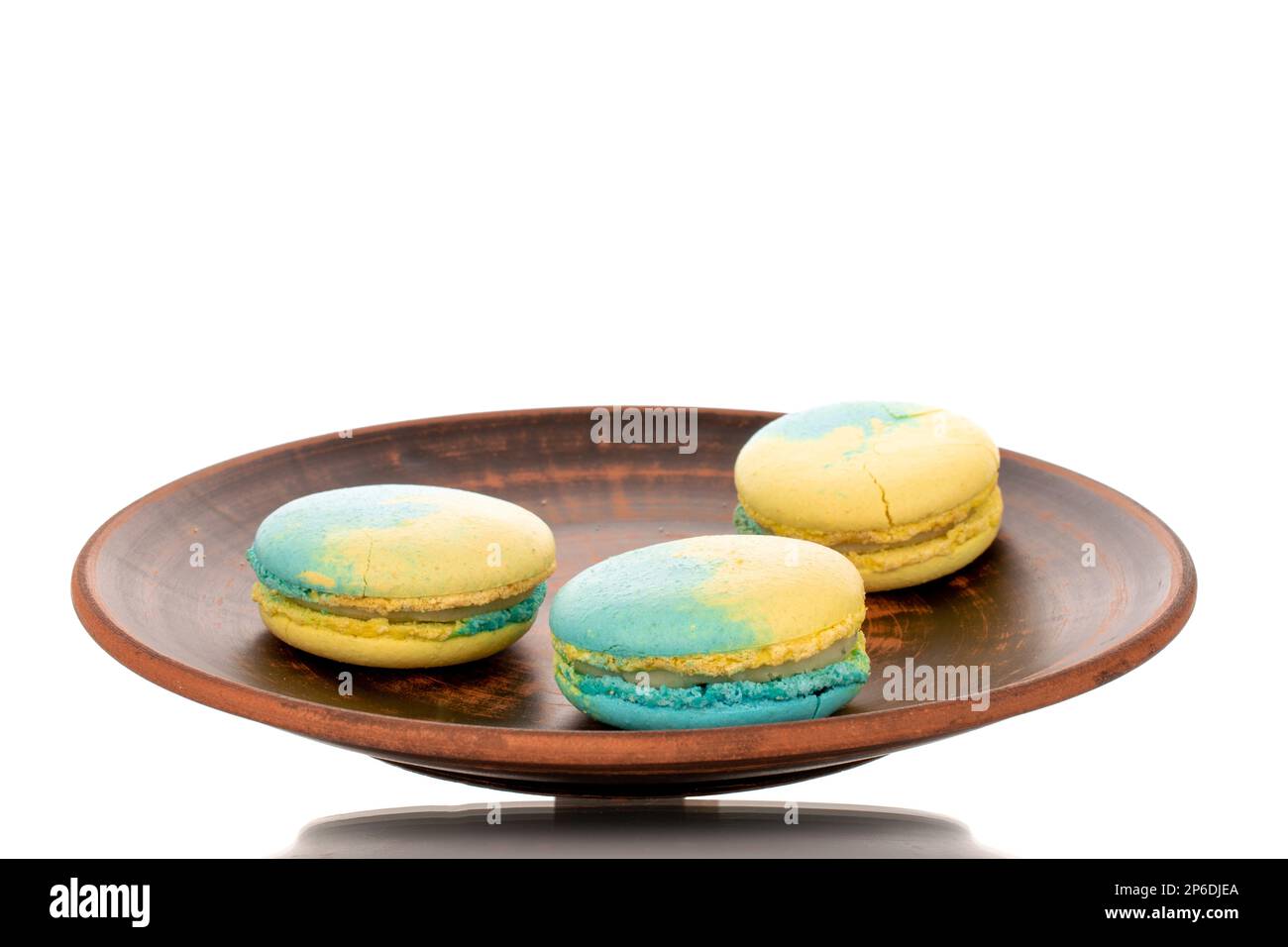 Three confectionery products, sweet macaroons on a clay plate, macro ...