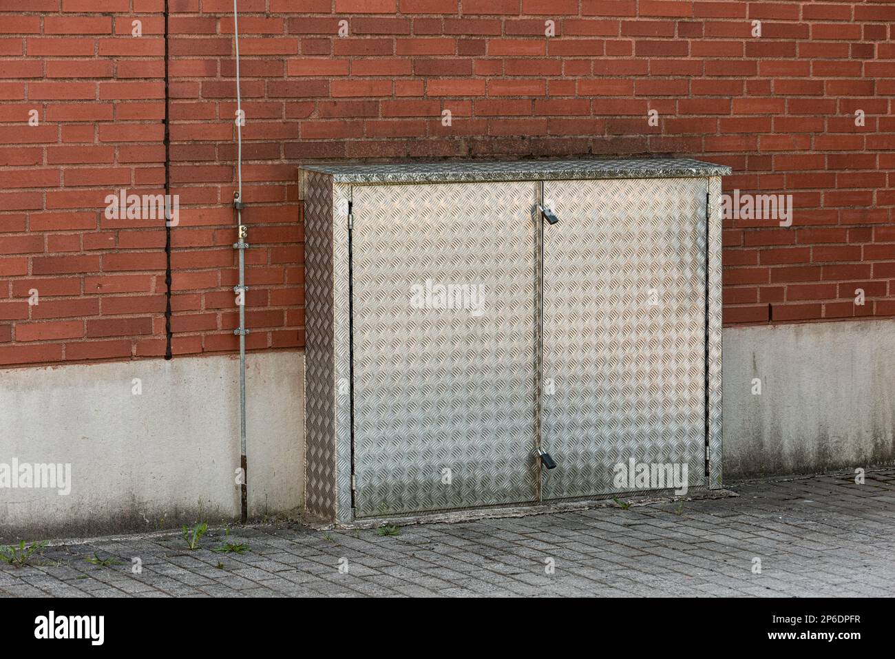 Locked off metal box by a building containing electrical equipment ...