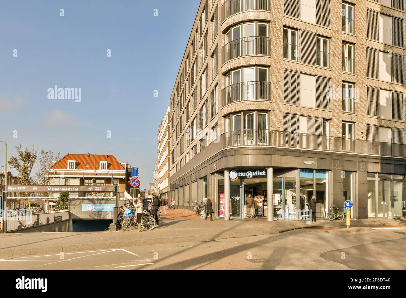 a building with people walking on the sidewalk in front of it and some ...