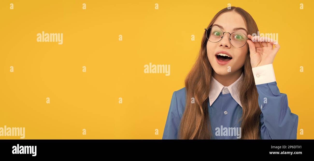 Curious school age girl child look through eyeglasses yellow background ...