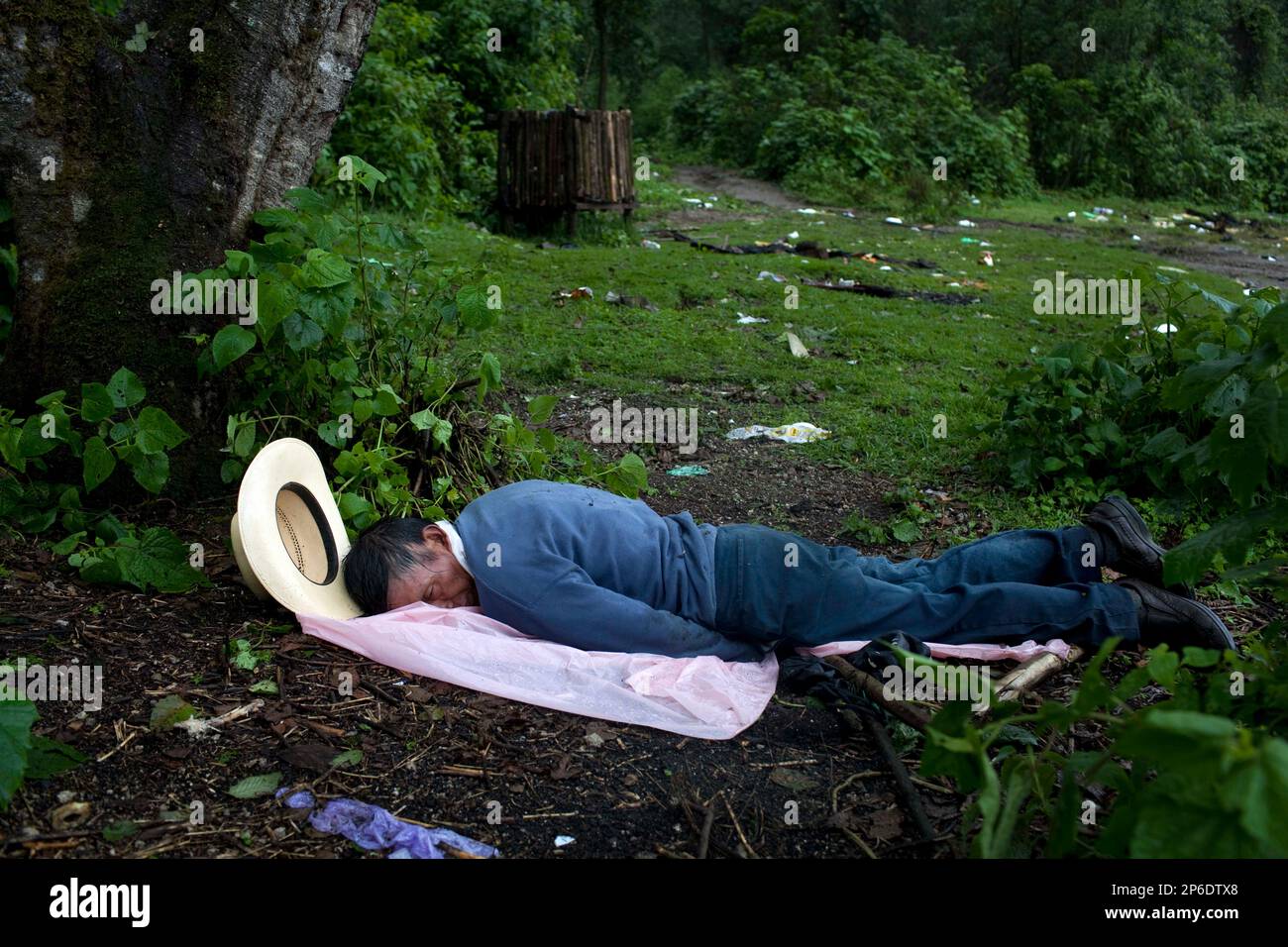 A drunken man sleeps face down after attending a Mayan rain ceremony on ...