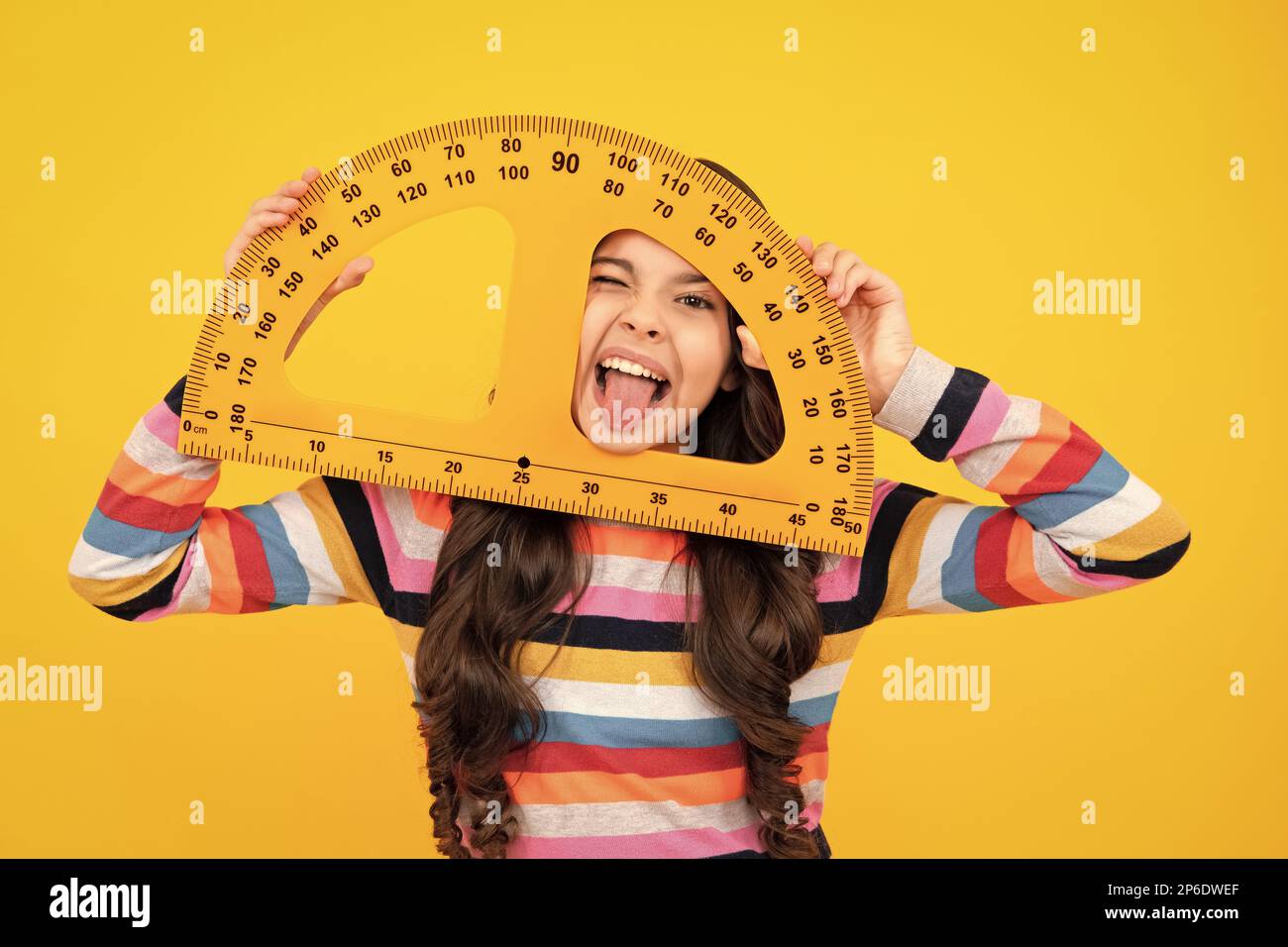 Funny face. Measuring school equipment. Schoolgirl holding measure for ...