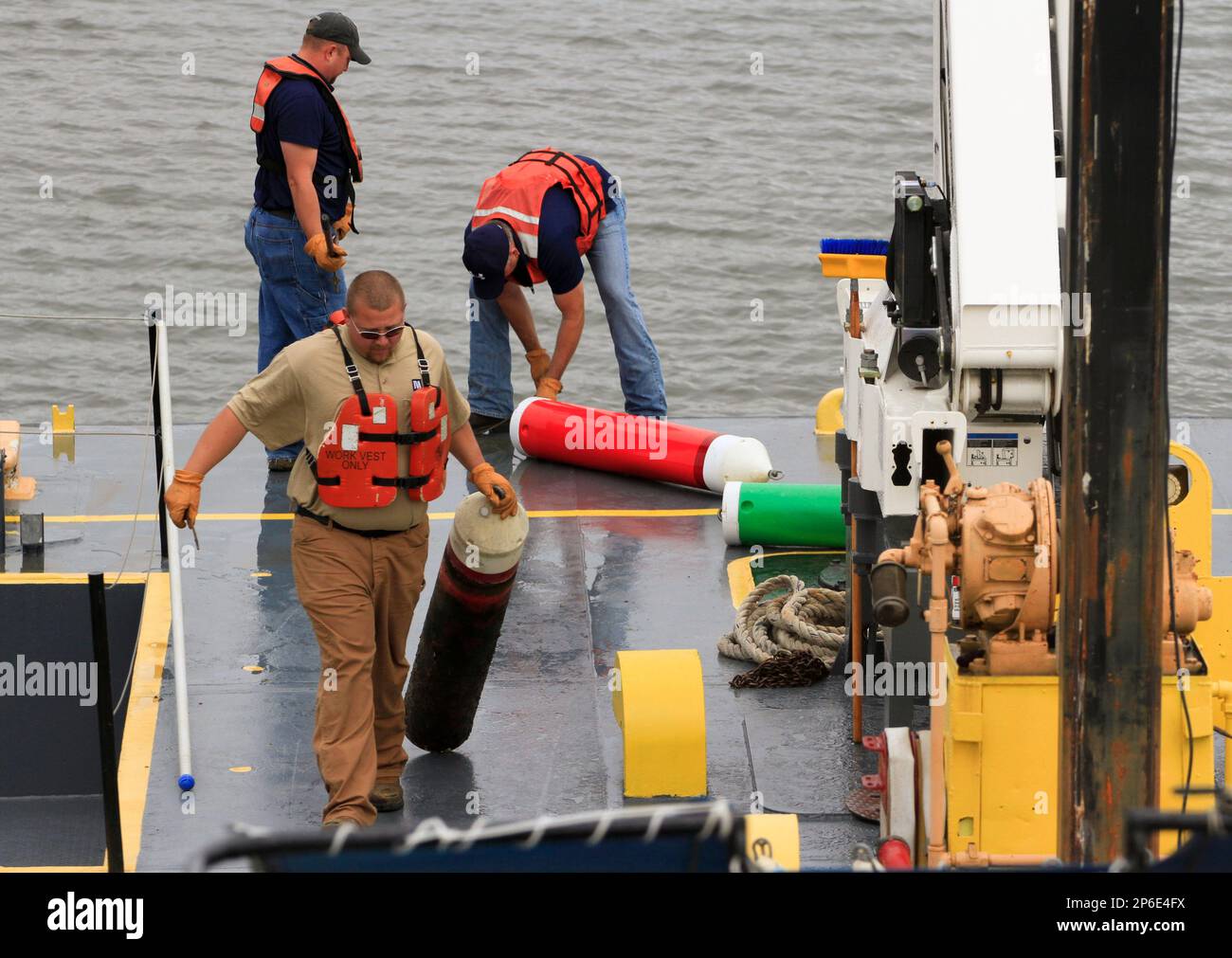 Mike Foster drags a damaged buoy across the deck as Chad Gower and ...