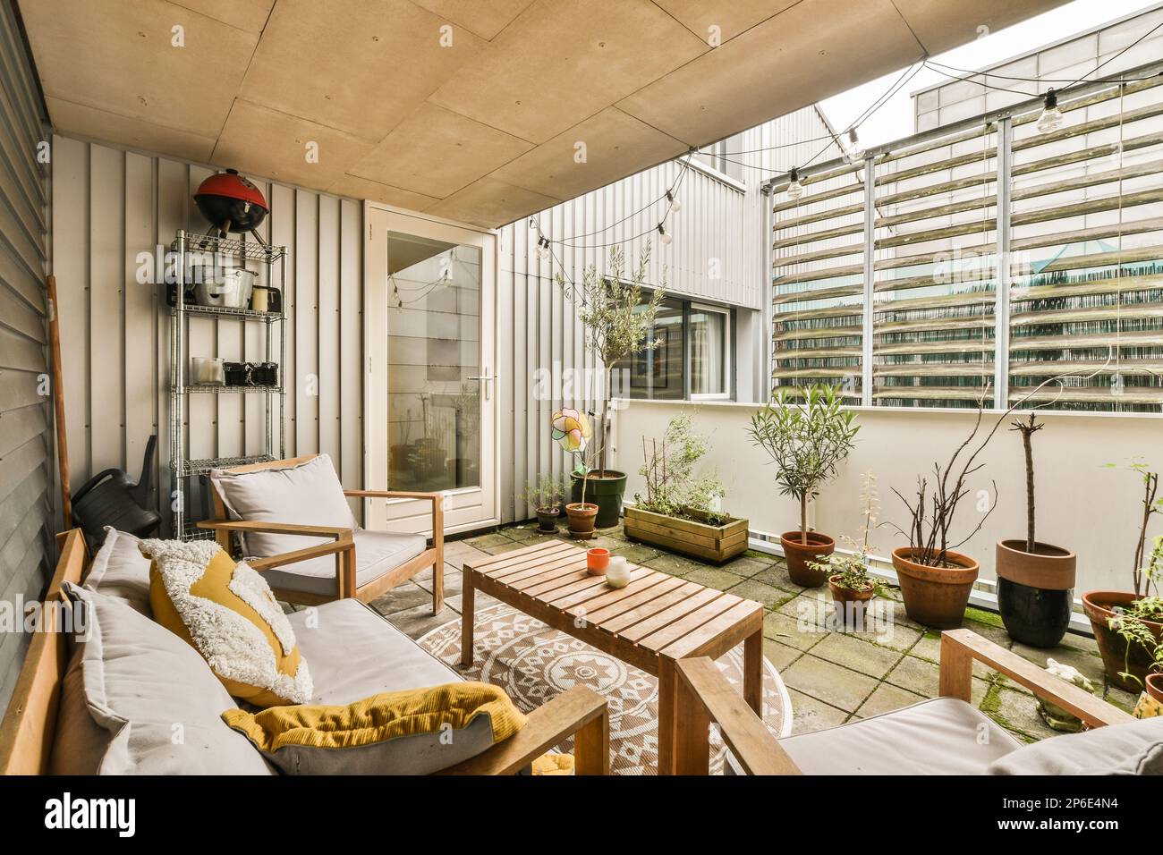 a balcony with furniture and potted plants on the outside wall, in ...
