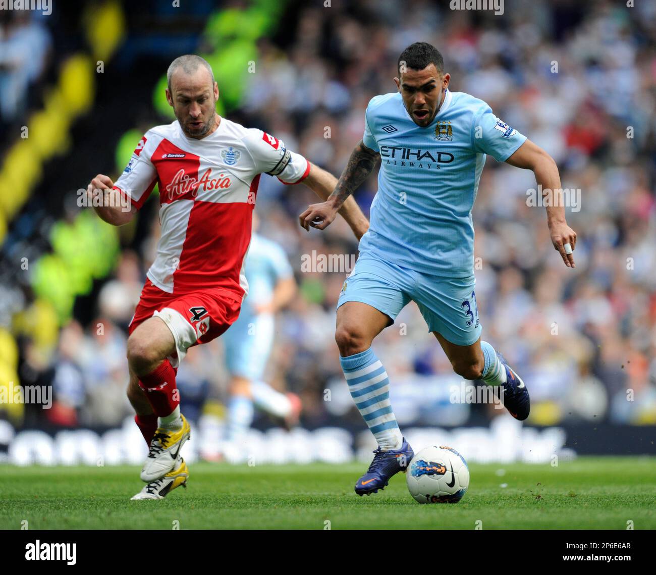 Shaun Derry of QPR tussles with Carlos Tevez of Manchester City ...