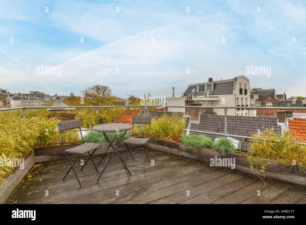 a rooftop with chairs, tables and plants on the top deck looking out to ...