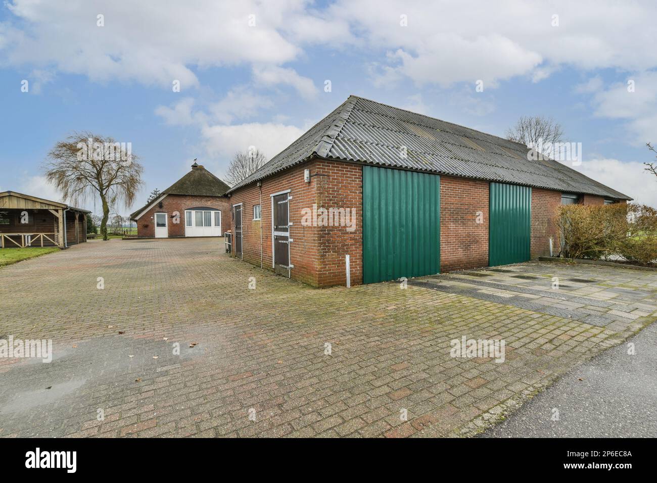 a brick building in the middle of an empty lot with two garages on one ...