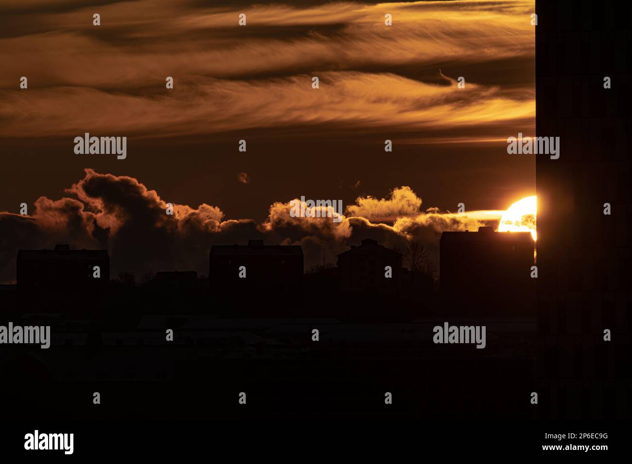 Sun setting behind apartment buildings Stock Photo - Alamy