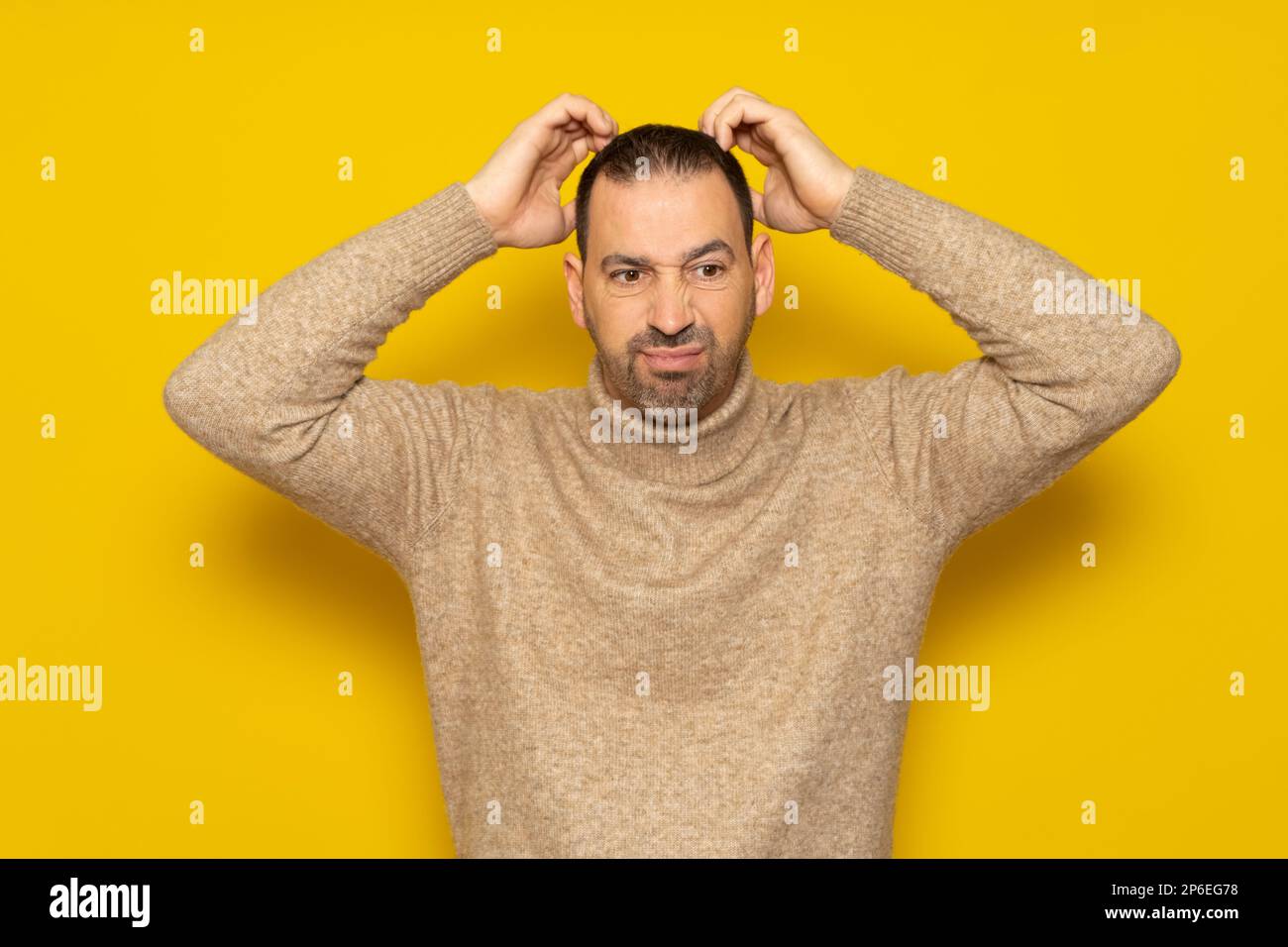 Bearded Hispanic Man Wearing A Beige Turtleneck Scratching His Head