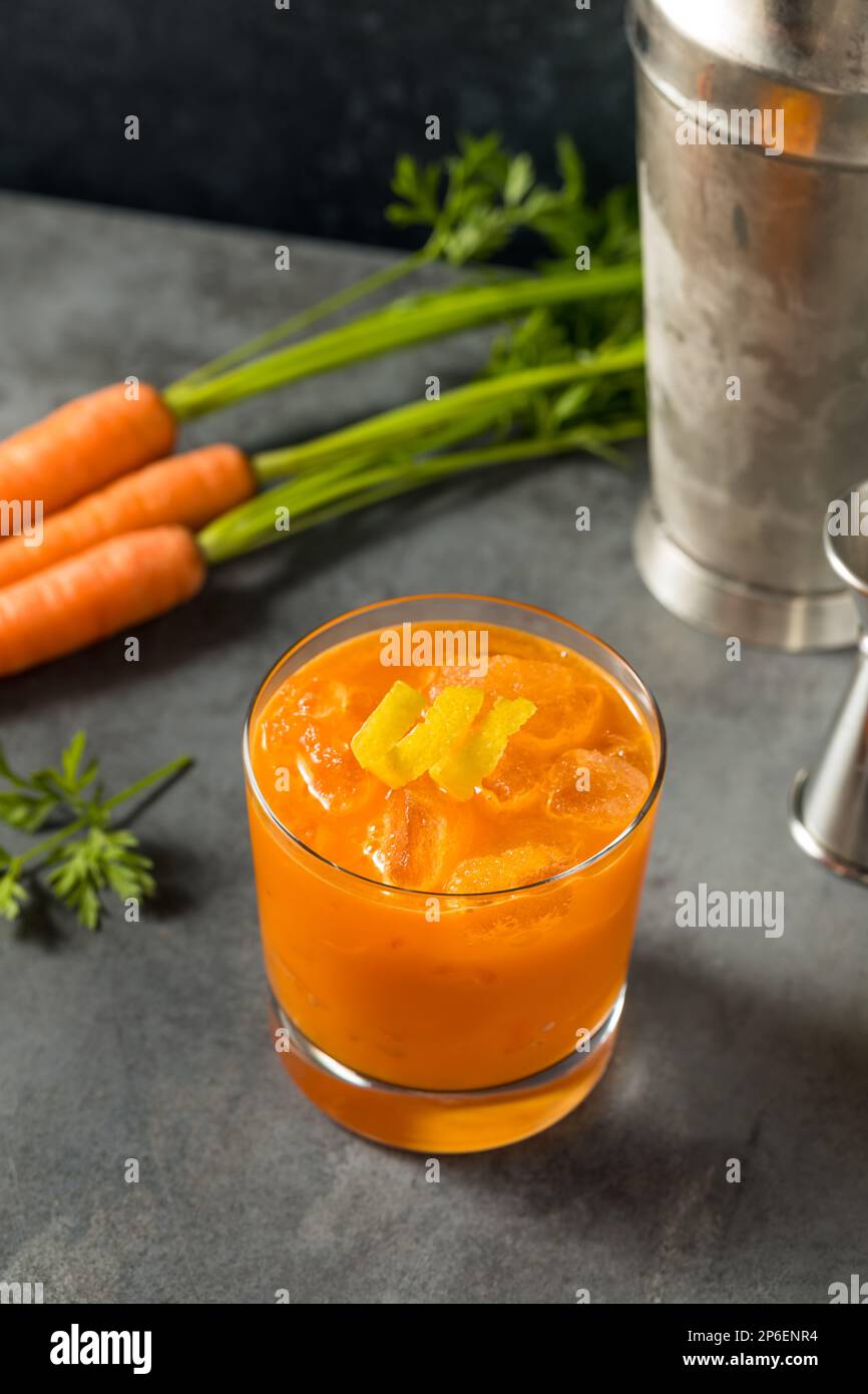 Cold Boozy Raw Carrot Bourbon Cocktail with Lemon Juice Stock Photo - Alamy