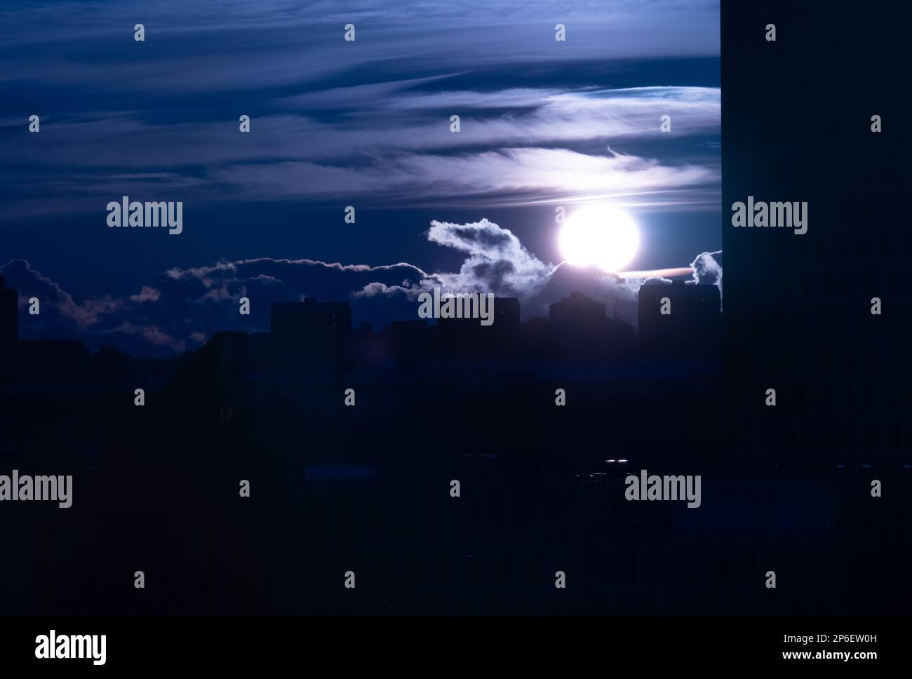 Sun setting behind apartment buildings Stock Photo - Alamy