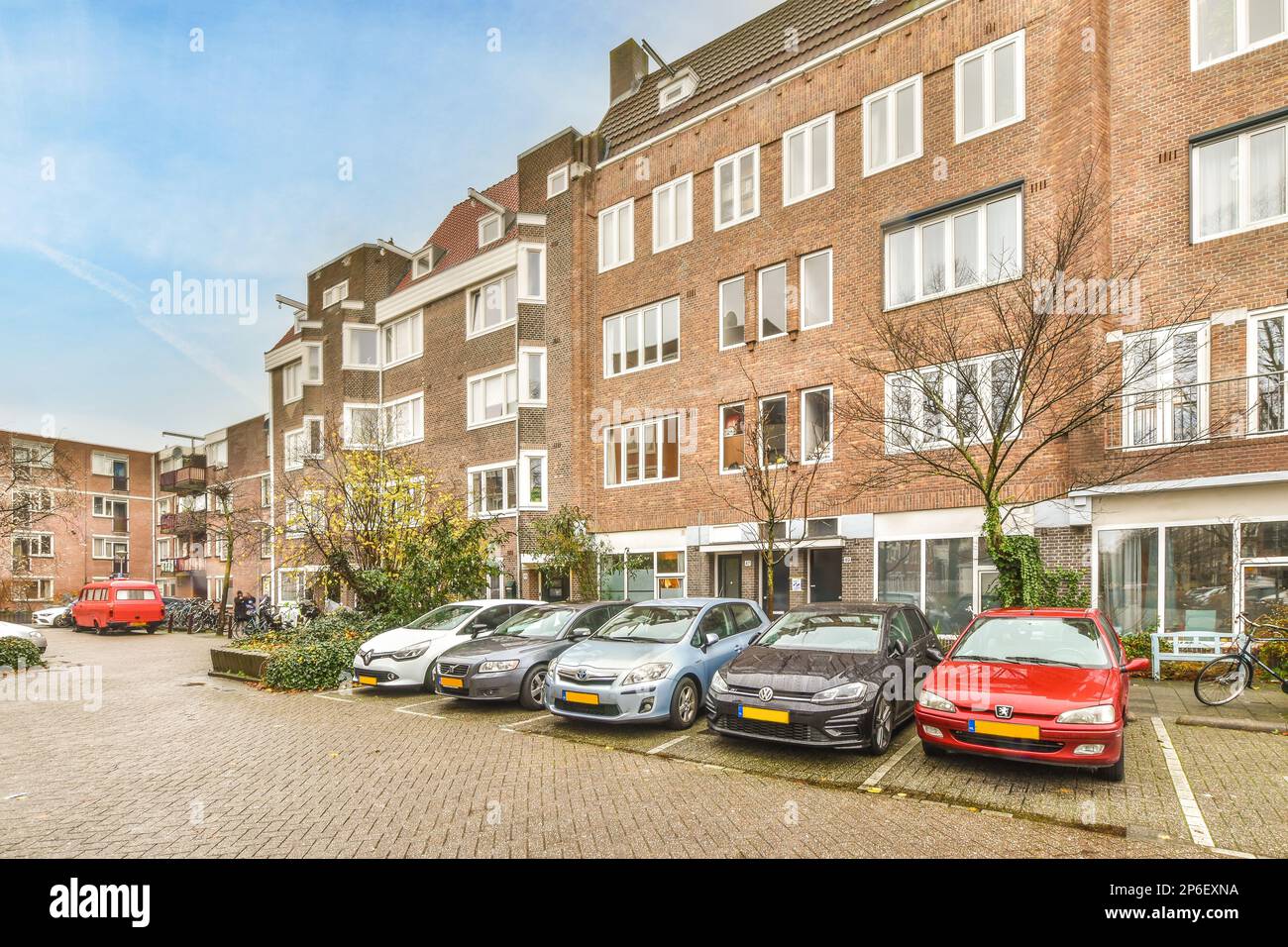 several cars parked on the side of a street in front of a brick ...