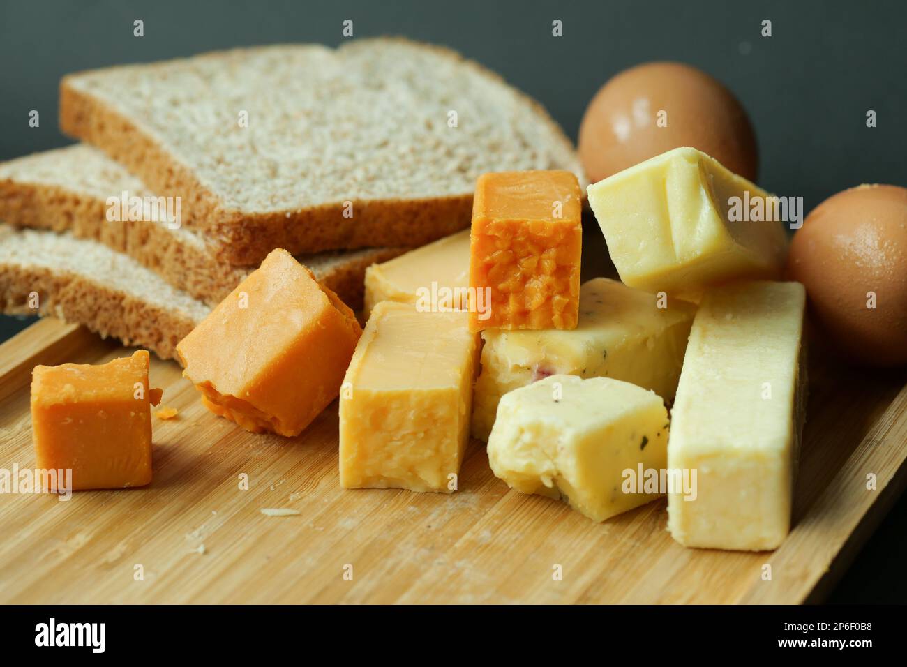 Cheese cubes green, yellow and red color on chopping board Stock Photo ...