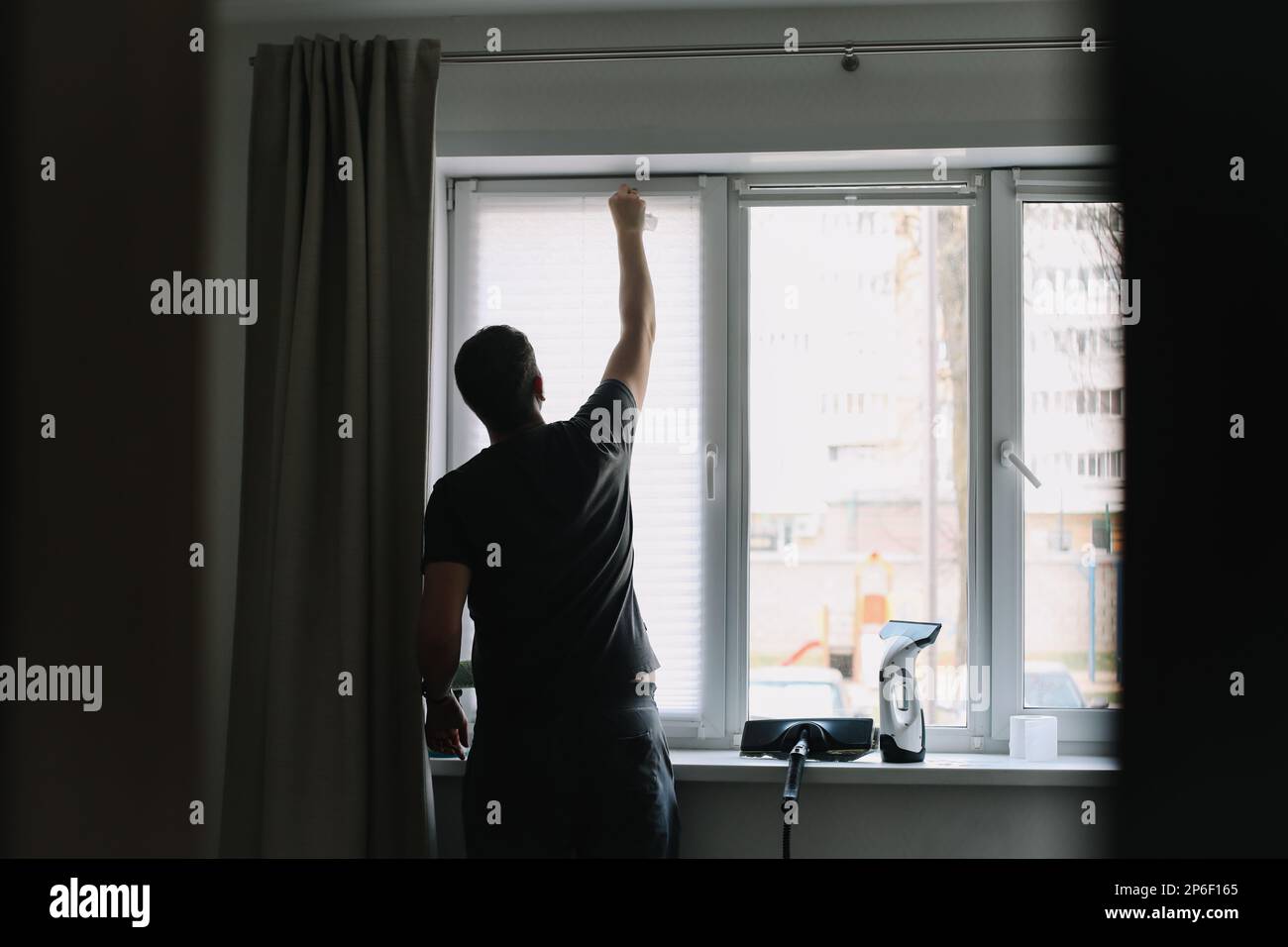 Man washing and cleaning window at home. Housework and housekeeping ...