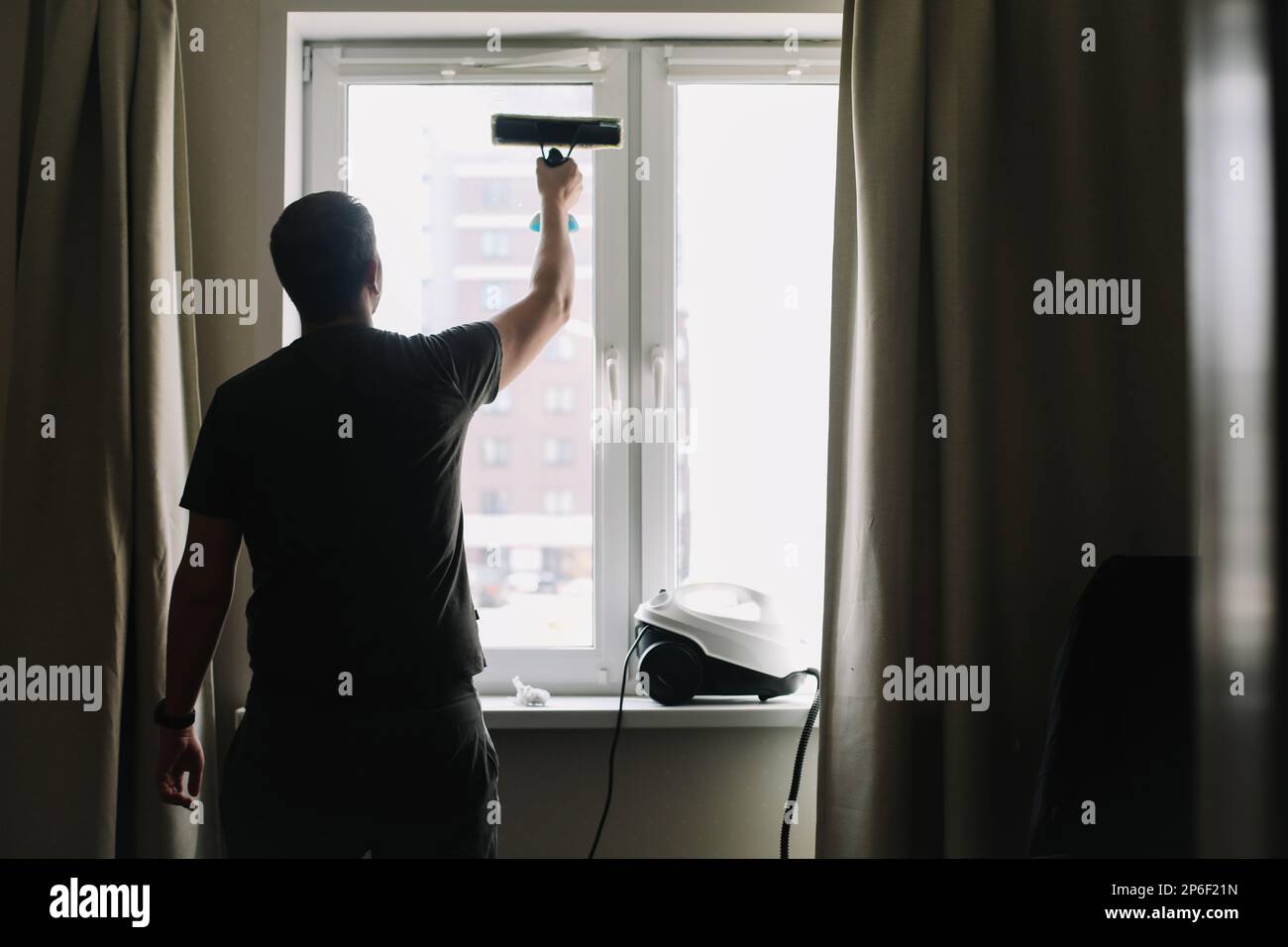 Man washing and cleaning window at home. Housework and housekeeping ...