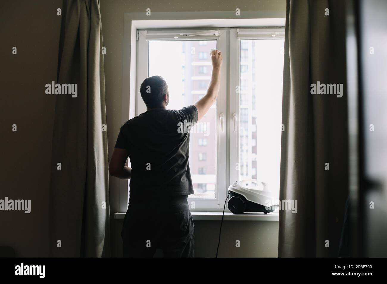 Man washing and cleaning window at home. Housework and housekeeping ...