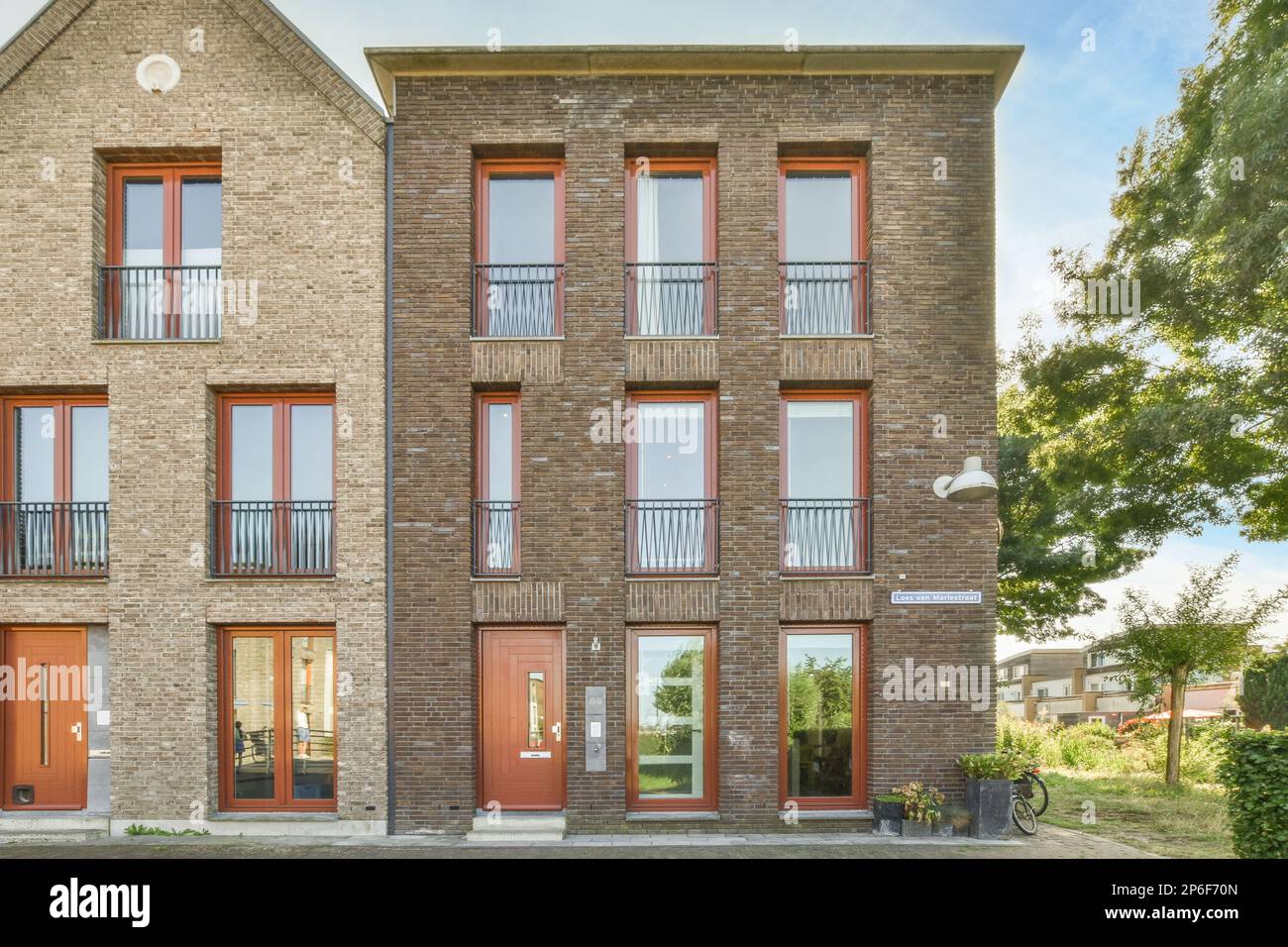 a two story brick apartment building with red doors and balks on the ...