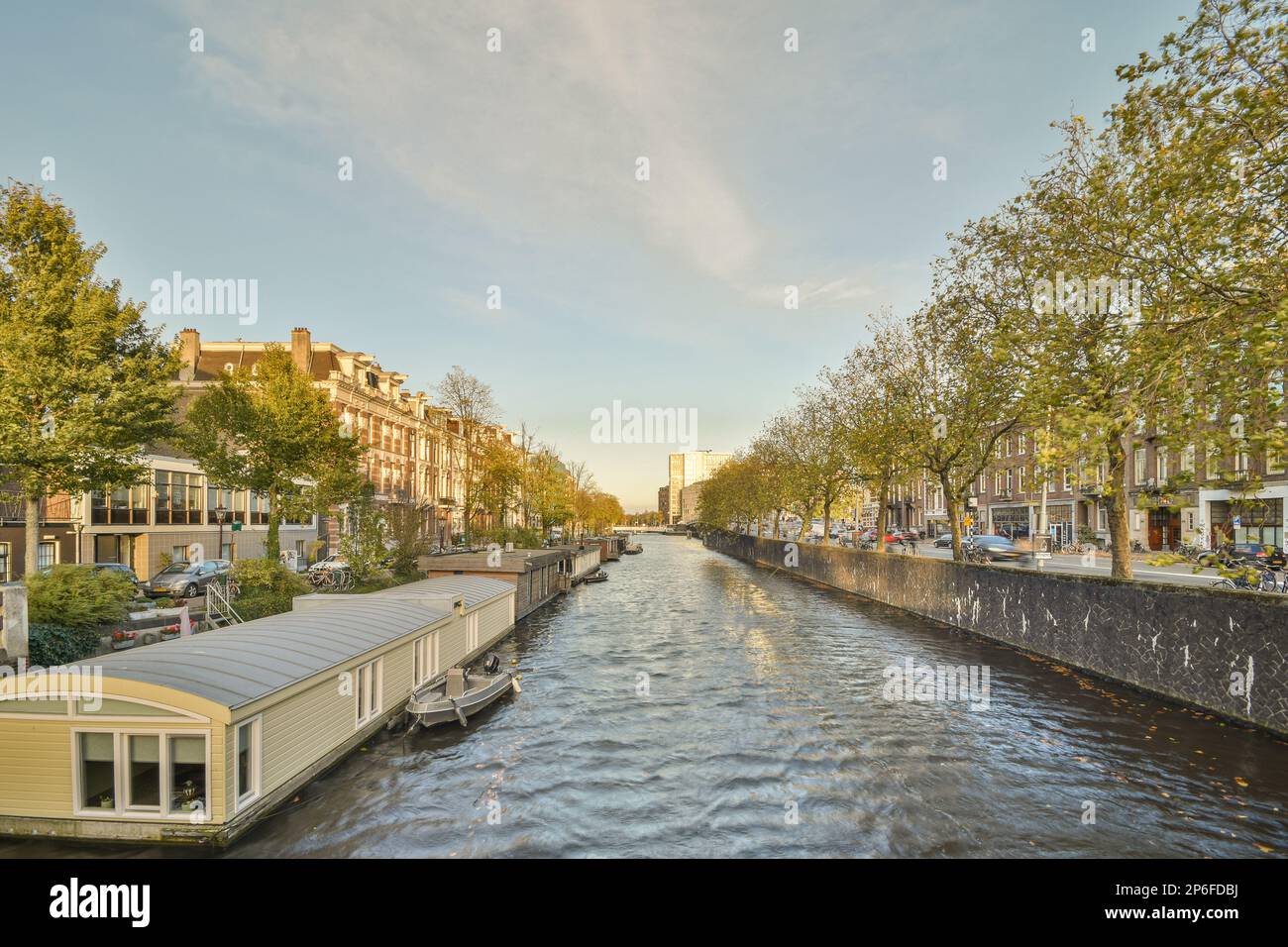 a canal with houses on both sides and boats in the middle one boat is ...