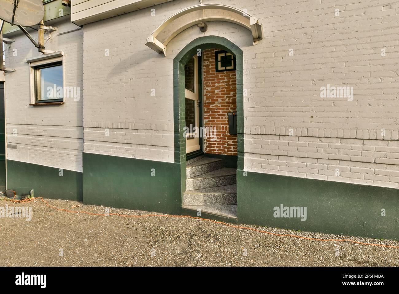 a brick building that has been painted green and white with an arched ...