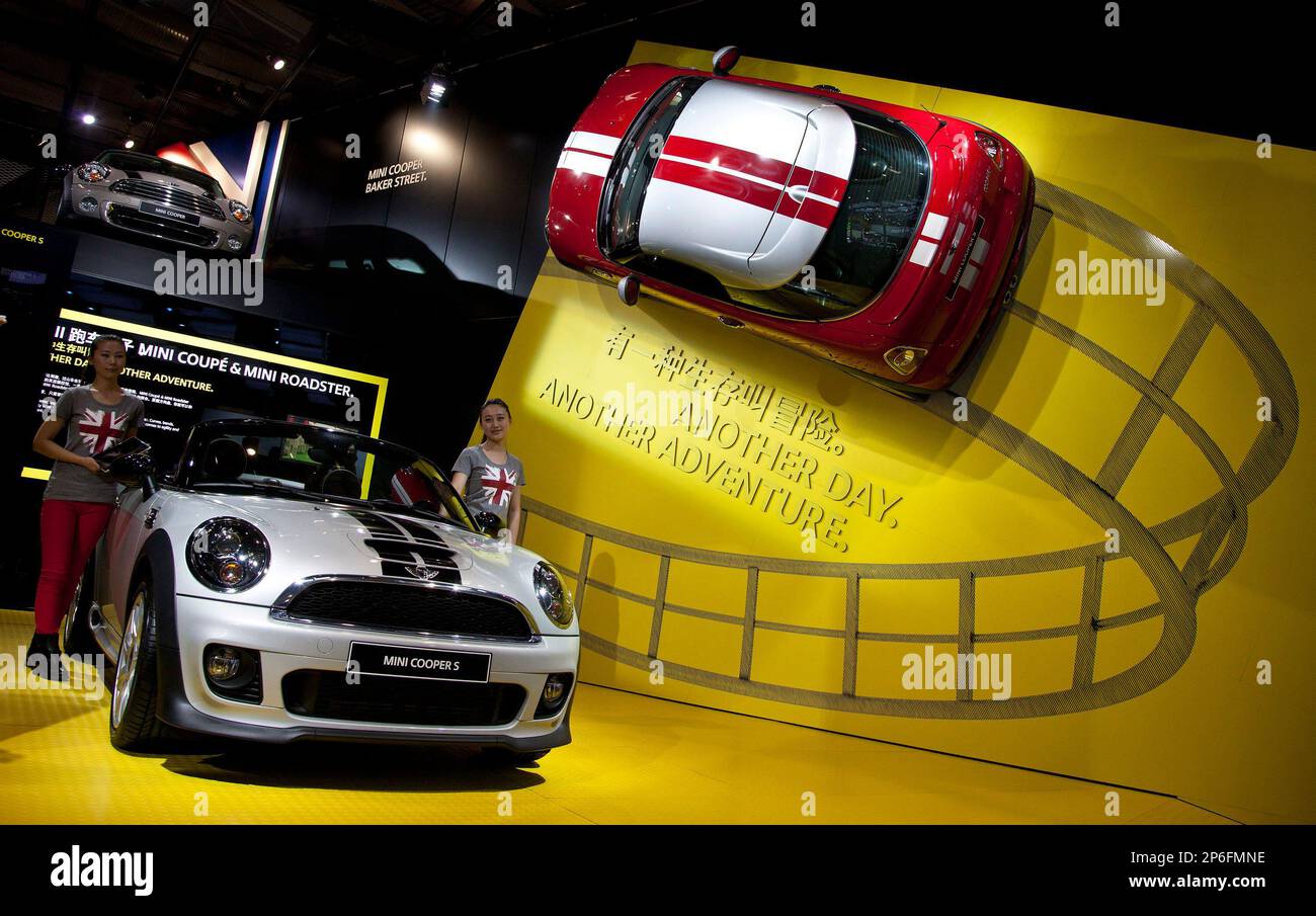 Models stand next to the Mini Cooper S on display at the Beijing ...