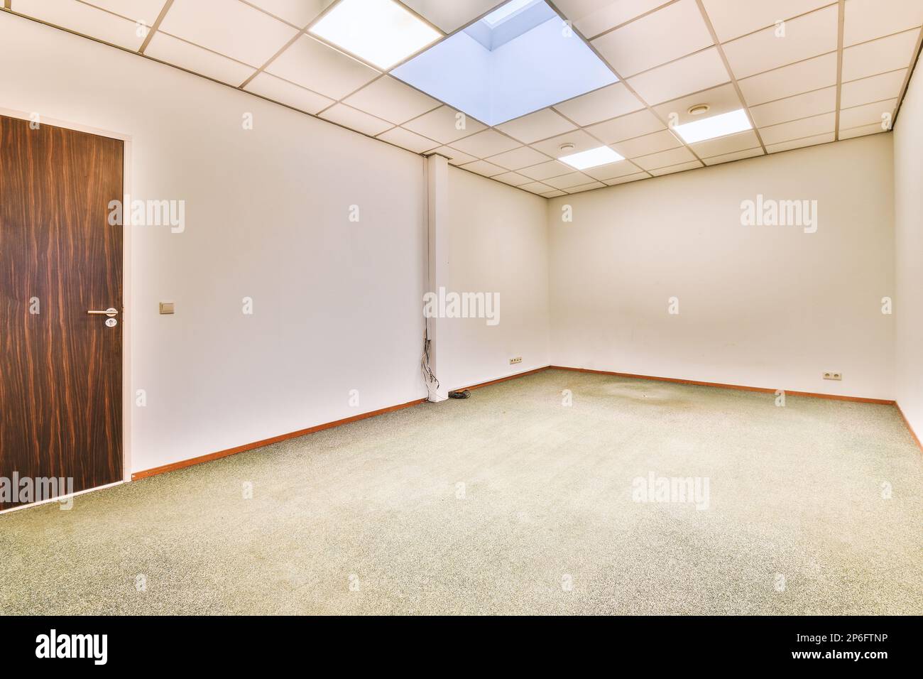 an empty room with a skylight on the ceiling and carpeted floor in ...
