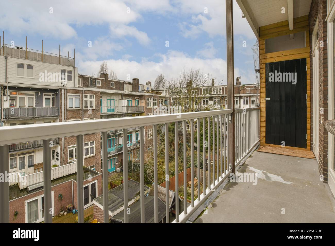 a balcony with some buildings in the background and a blue sky overhead ...