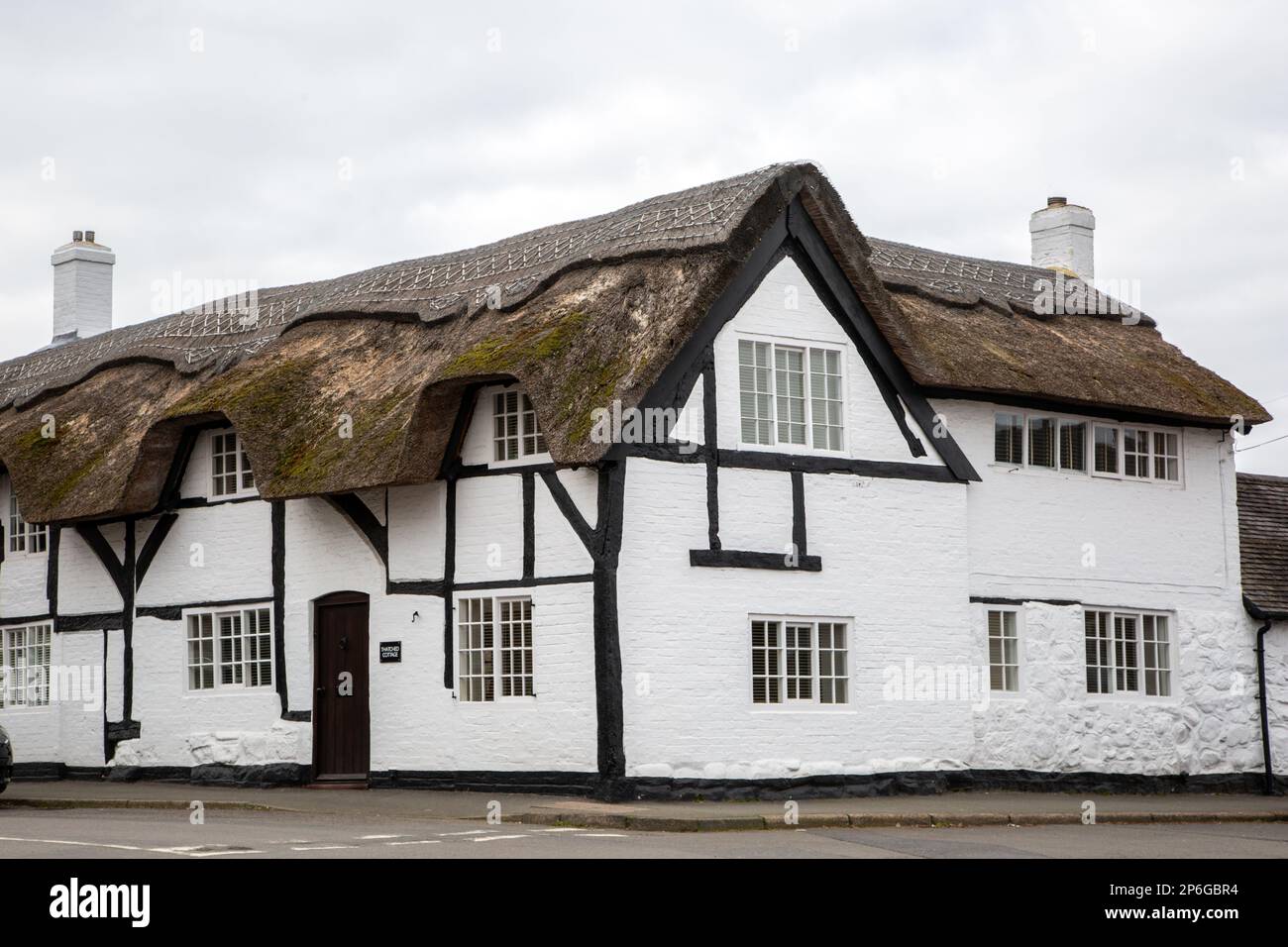 Old traditional black and white half timbered thatched roof cottage in ...
