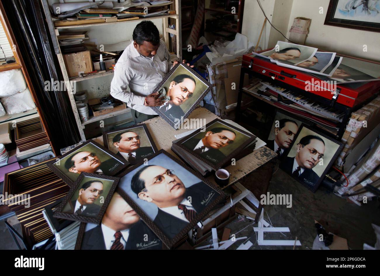 An Indian worker cleans a portrait of Bhim Rao Ambedkar, a key ...